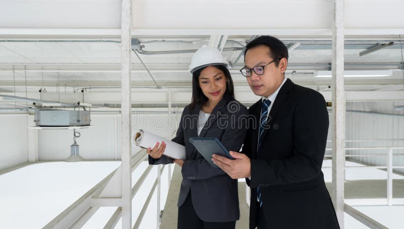 Female Engineer in Hardhat Hold the Construction Plan while Looking at ...