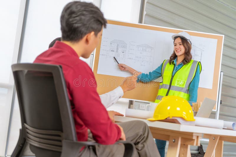Female Engineer Presenting Building Drawing To Her Contractor Team and ...