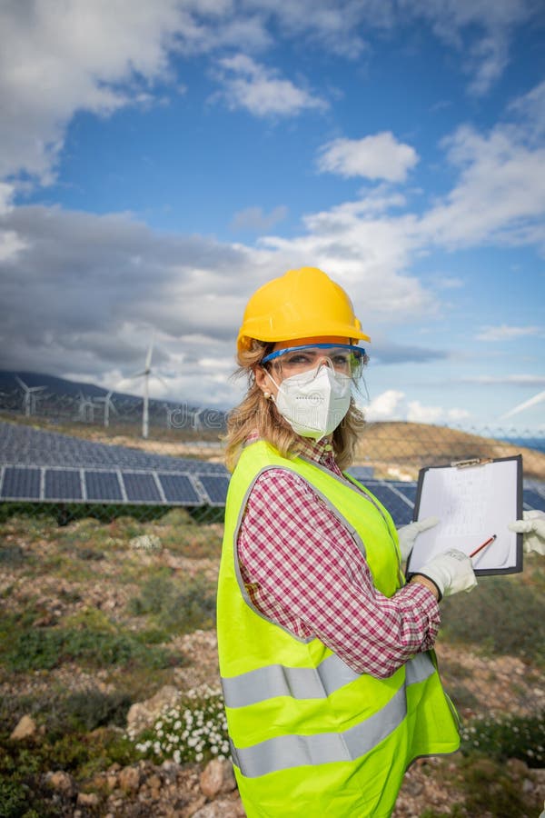 A Female Engineer at a Solar Power Plant during Work, she Wears ...