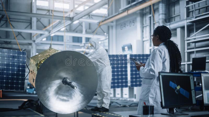 Female Engineer Uses Tablet Computer while Working on Satellite ...
