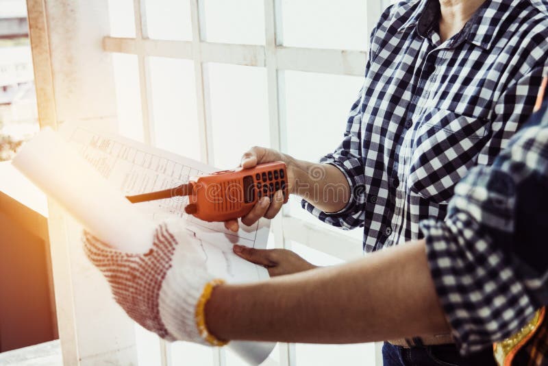 Female Engineer Discussing Construction Work with Blueprints and ...