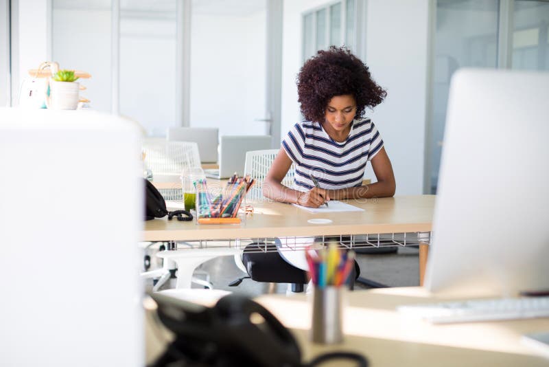 Female Executive Writing on Paper at Her Desk Stock Image - Image of ...