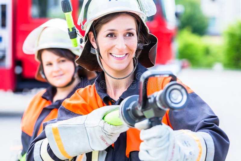 Female Fire Fighters Spouting Water To Extinguish Stock Photo - Image ...