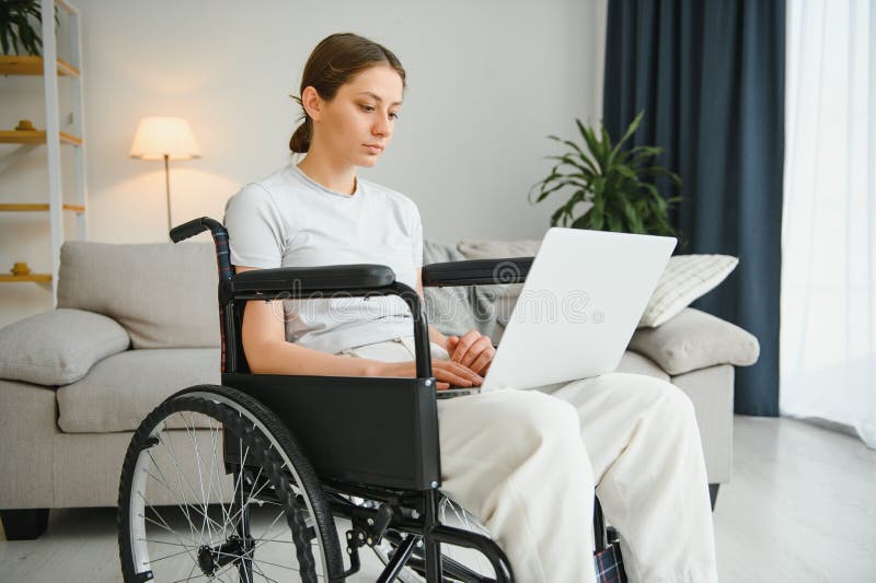 Female Freelance Programmer Sitting In Wheelchair And Using Computers While Coding Web Game At