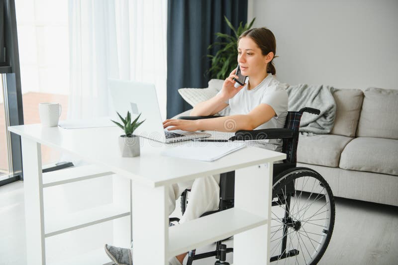 Female Freelance Programmer Sitting In Wheelchair And Using Computers While Coding Web Game At