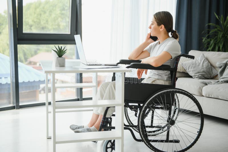 Female Freelance Programmer Sitting In Wheelchair And Using Computers While Coding Web Game At