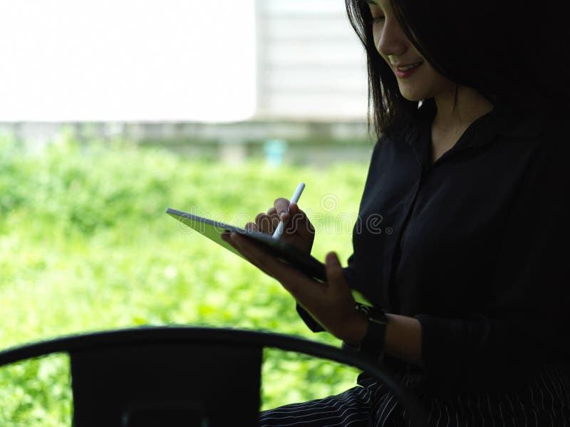 Female Freelancer Using with Digital Tablet while Relaxed Sitting in ...