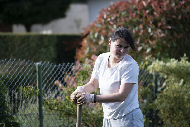 Female Gardener Working in the Garden with a Hoe and Rake Stock Image ...