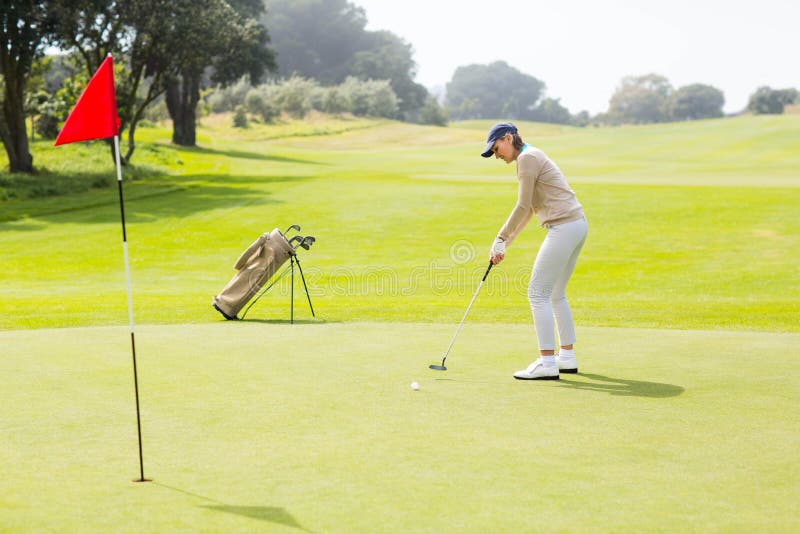 Female Golfer Putting Her Ball Stock Image - Image of club, holding ...