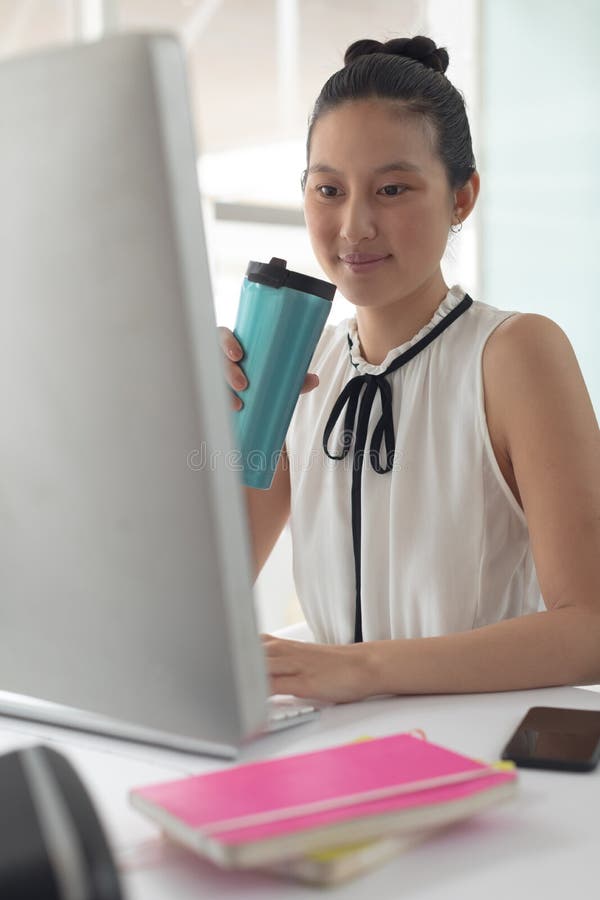 Female Graphic Designer Drinking Water while Working on Computer at ...