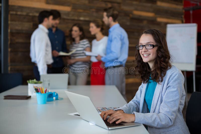 Female Graphic Designer Using Laptop Stock Photo - Image of coworker ...