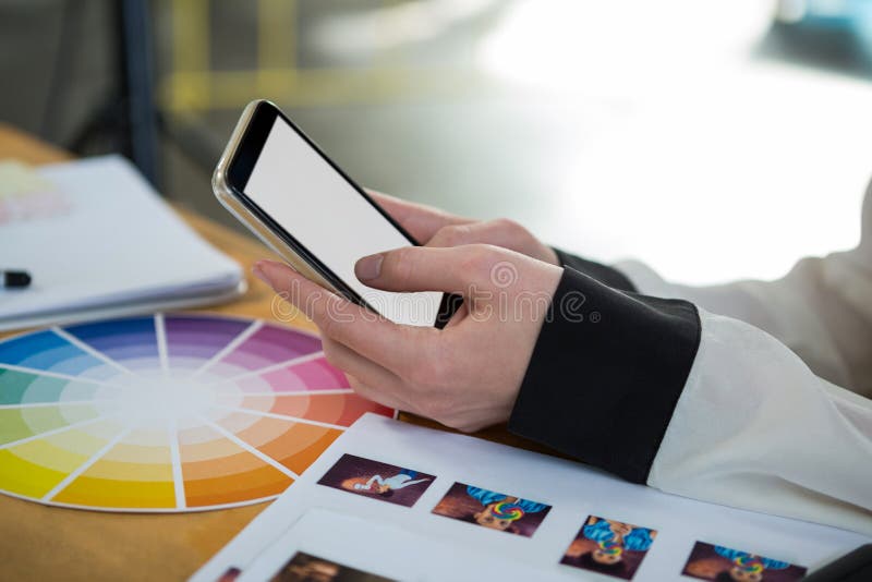 Female Graphic Designer Using Mobile Phone at Desk Stock Photo - Image ...