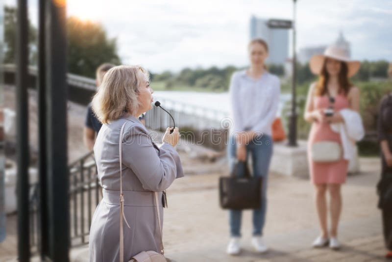 Female Guide Communicates with a Group of Tourists. Stock Image - Image ...