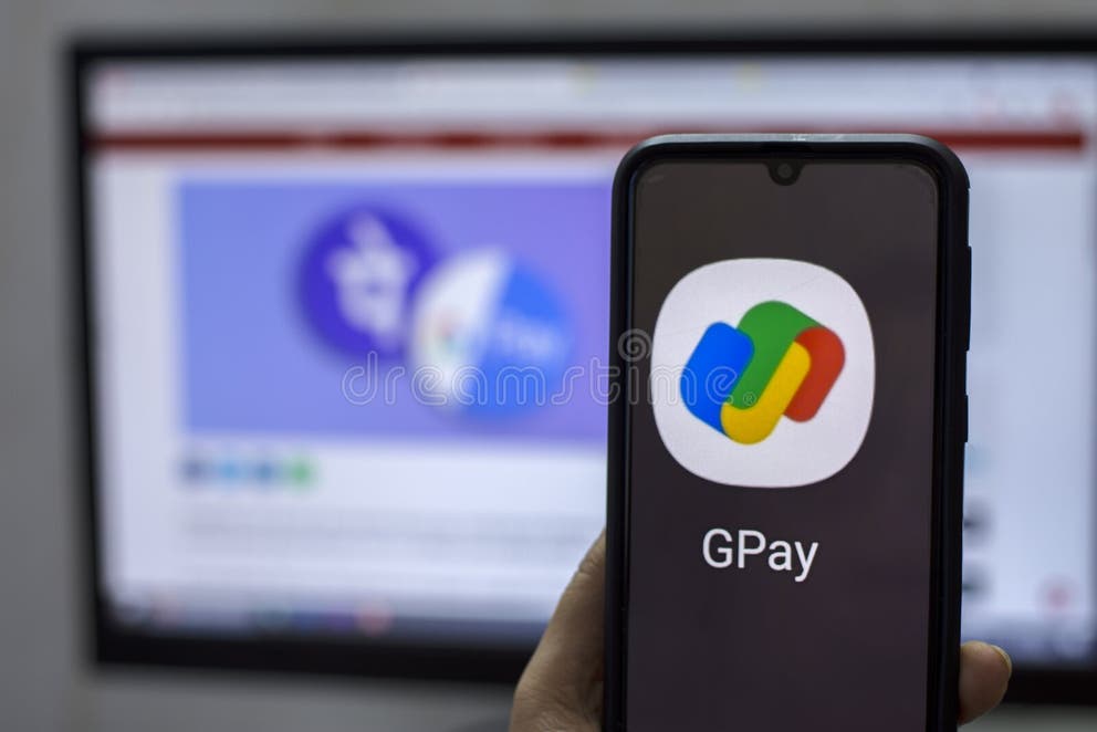 A Female Hand Holding a Android Smart Phone in Front of a Desktop ...