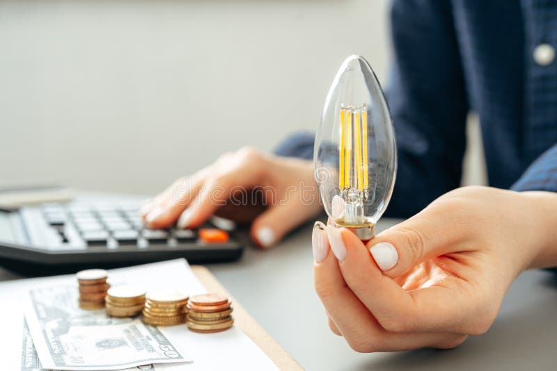 Female Hand Holding a Light Bulb Above the Table Stock Image - Image of ...