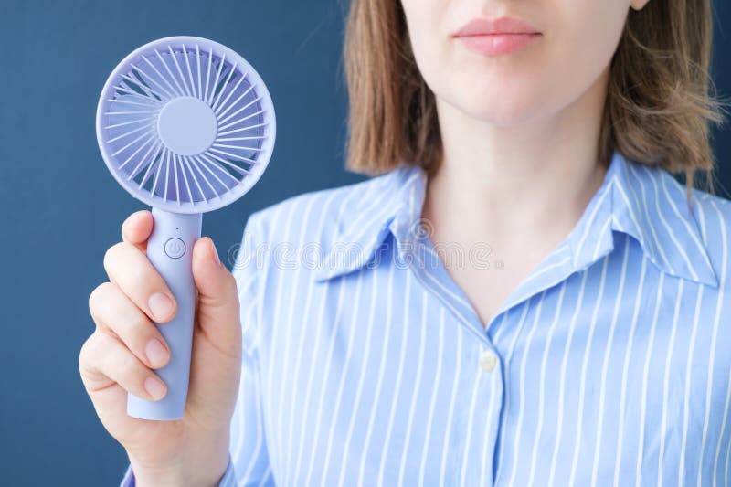 Female Hand Holding Mini Fan on Blue Background Close-up. Stock Photo ...