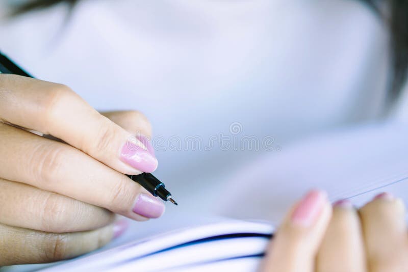 Female Hand Holding a Pen Writing Message on Notebook Stock Image ...