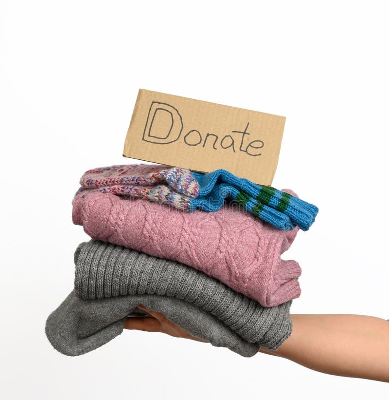 Female Hand Holding a Stack of Clothes, Help and Volunteering Concept ...