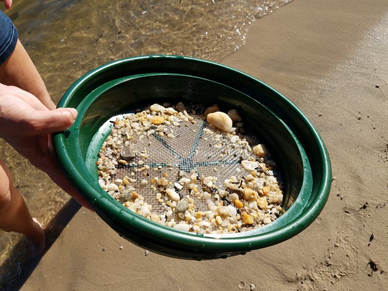 Female Hand Holding Strainer with Stones at Beach with Water Stock ...