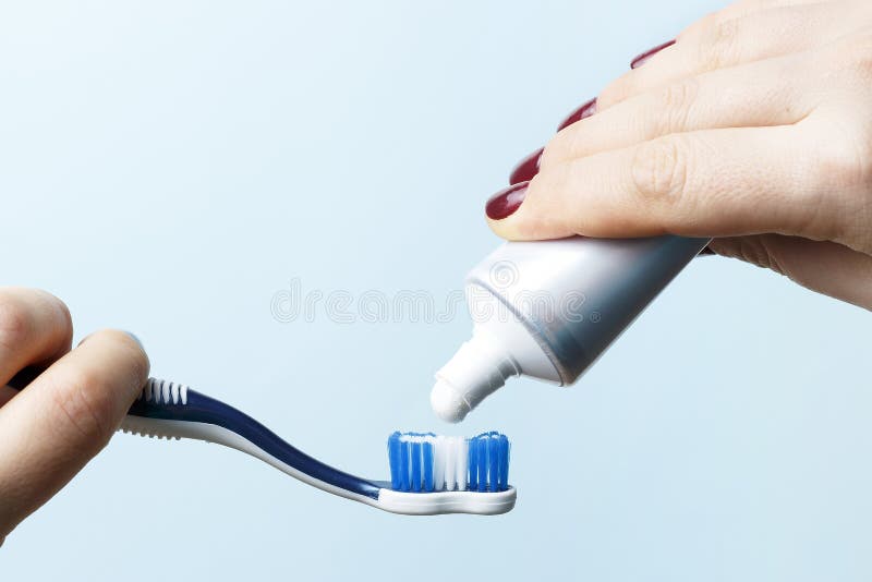 Female Hand Holding a Toothbrush and Squeezing Toothpaste Stock Photo ...