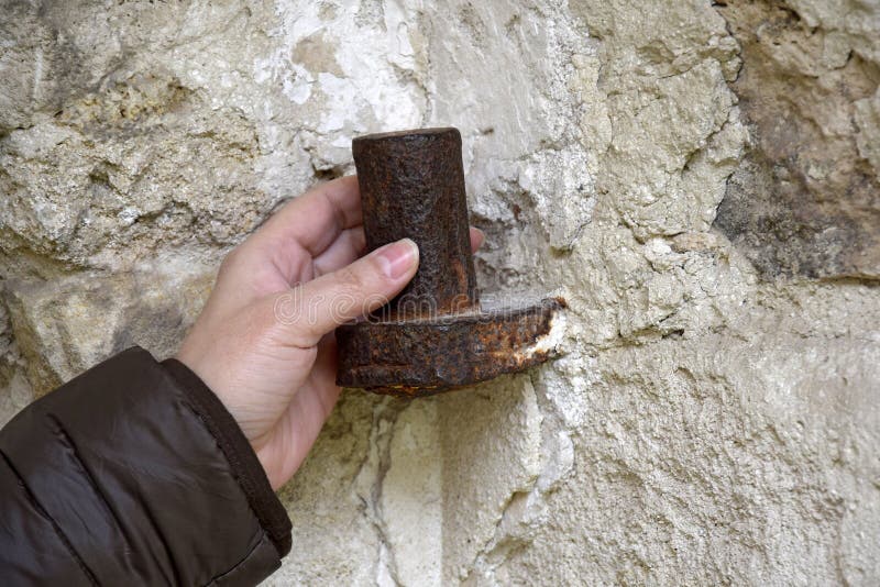 Female Hand Holds Large Antique Loop Embedded in Stone Wall. Old Metal ...