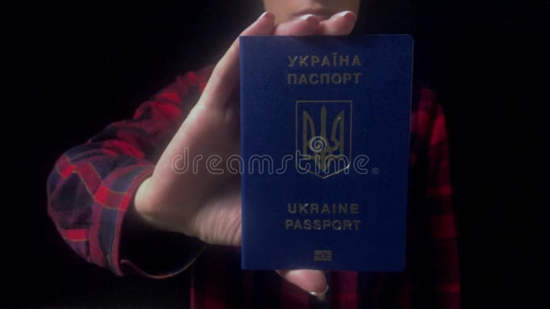 Female Hand Holds Ukrainian Passport On Black Background Close Up