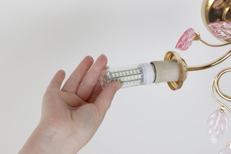 Female Hand Inserts a Light Bulb into the Threaded Socket. Installation ...