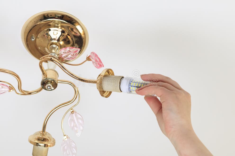 Female Hand Inserts a Light Bulb into the Threaded Socket. she is ...