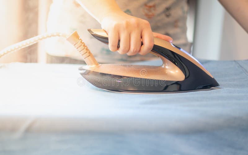 Female Hand Ironing Clothes on Iron Board at Home in the Laundry Day ...