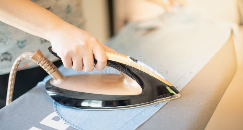 Female Hand Ironing Clothes on Iron Board at Home in the Laundry Day ...