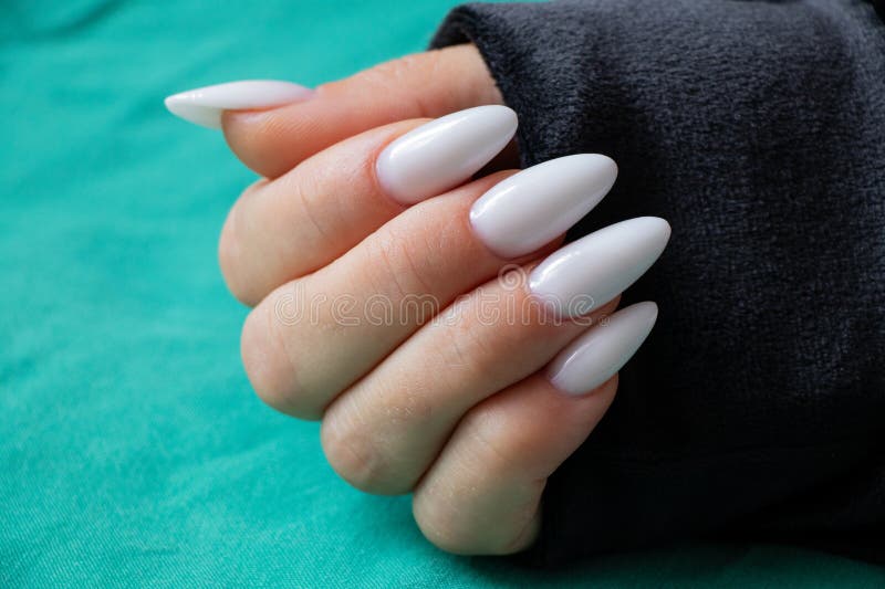 Female Hand with Long Sharp White Manicure on Green Fabric Stock Image ...