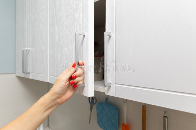 Female Hand Opens Kitchen Cabinet with Utensils Stock Image - Image of ...