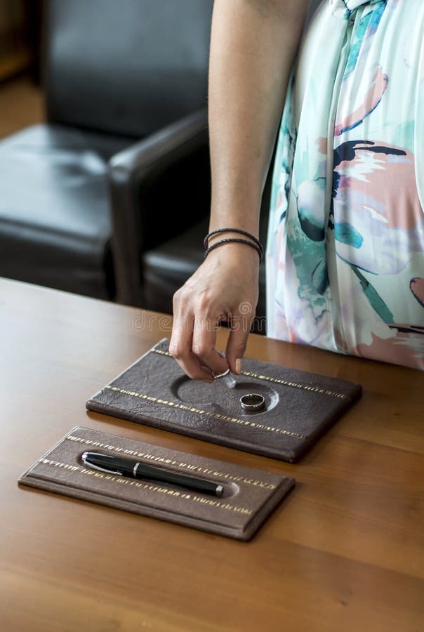 Female Hand Picking Up Wedding Ring from Table for Groom during ...