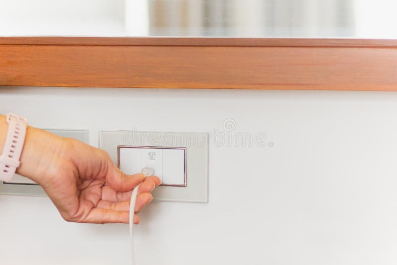 Female Hand Plug in Internet Cable Wire into Socket on the Wall. Stock ...