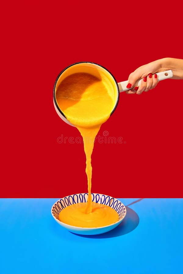 Female Hand Pouring Delicious Cheese Soup into Plate on Blue Tablecloth ... Female Hand Pouring Delicious Cheese Soup into Plate on Blue Tablecloth ...