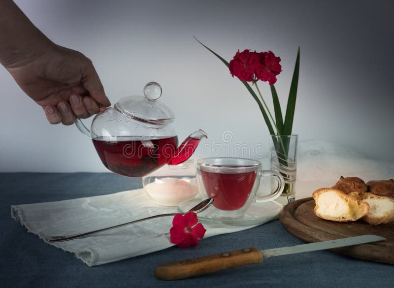 Female Hand Pouring Tea from a Teapot into Glass Cup Stock Photo ...
