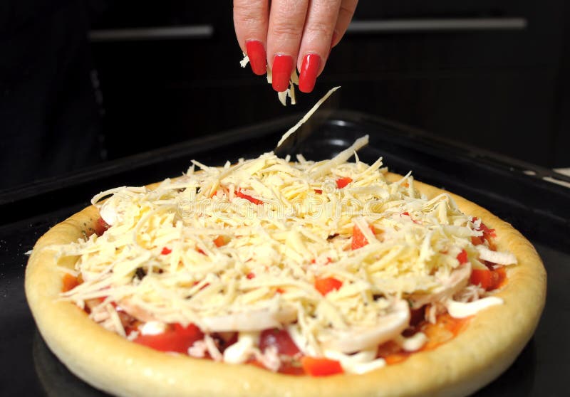 A Female Hand Sprinkles a Pizza with Grated Cheese Stock Photo - Image ...