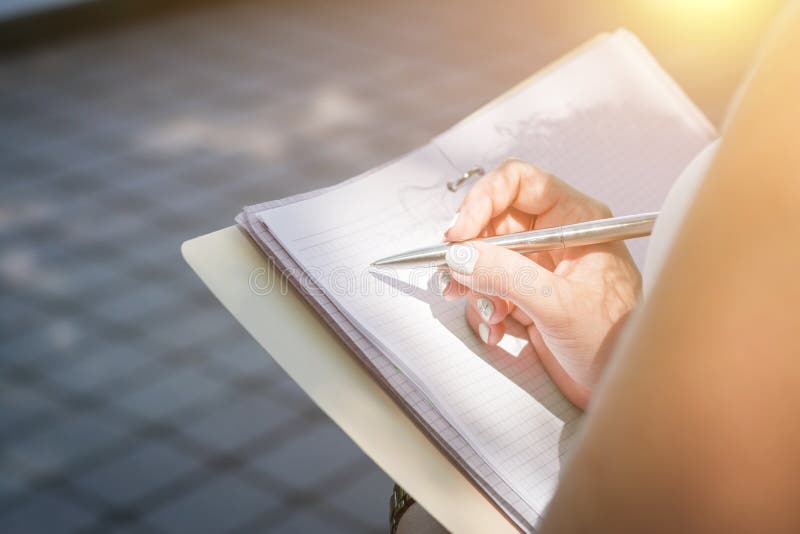 Female Hand Takes Notes in a Notebook in Nature Stock Photo - Image of ...
