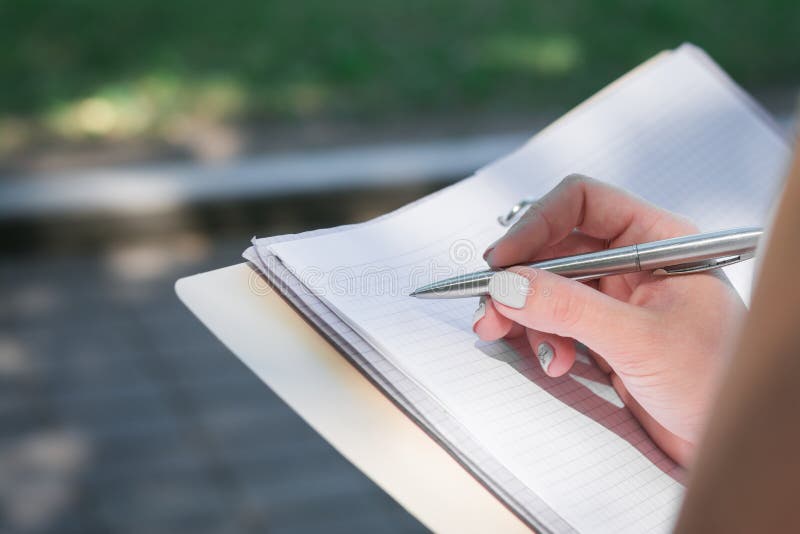 Female Hand Takes Notes in a Notebook in Nature Stock Image - Image of ...