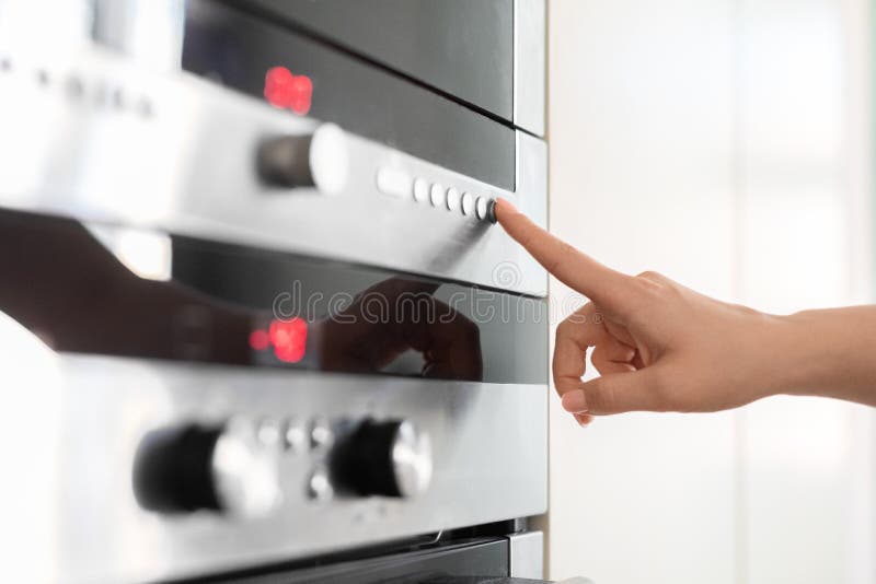 Female Hand Touching Control Panel on Electric Oven in Kitchen Stock ...