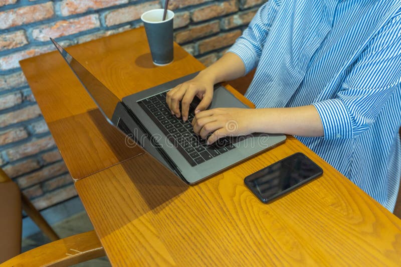Female Hand Typing Laptop Keyboard Next To Smartphone on Table Stock ...