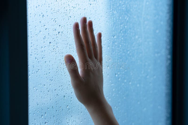 Female Hand at the Window during the Rain. Glass in Drops of Water ...