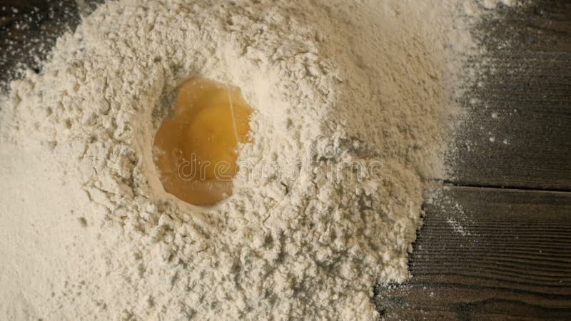 Female Hands Break the Egg into Flour on Old Wooden Kitchen Table Stock ...