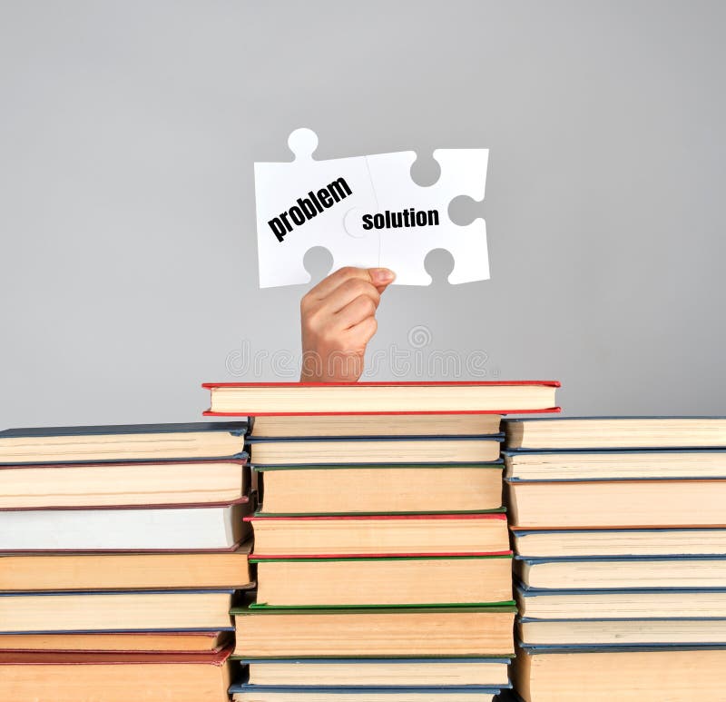 Female Hands Holding Big White Puzzles Over a Stack of Books Stock ...