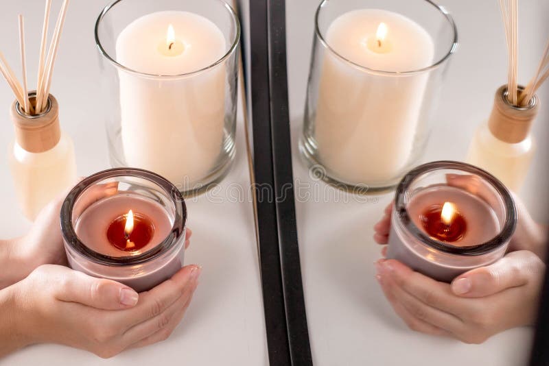 Female Hands Holding a Burning Scented Candle. Reflection in the Mirror ...