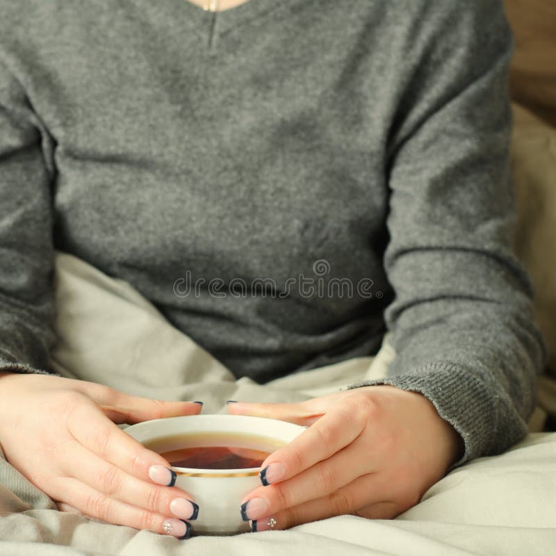 Female Hands Holding a Cup of Hot Tea on Warm Blanket. Stock Image ...