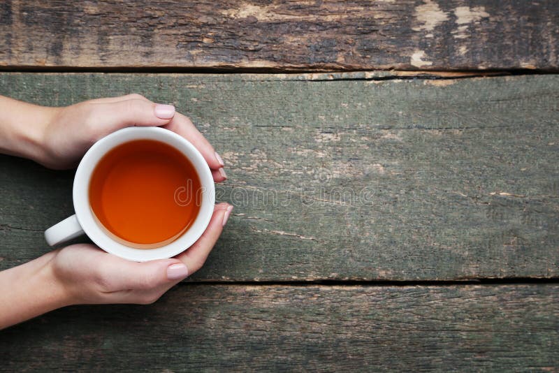 Hands holding cup of tea stock photo. Image of plant - 127961956