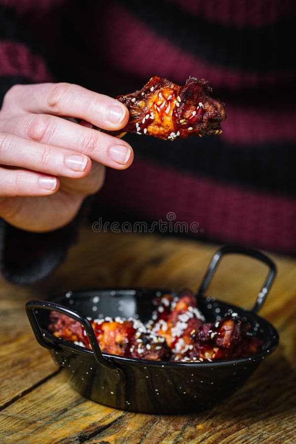 Female Hands Holding Fried Chicken Wing Stock Photo - Image of straw ...