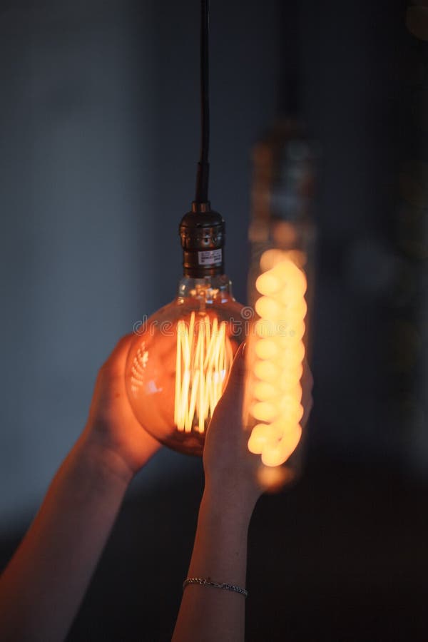 Female Hands Holding a Large Incandescent Lamp in the Studio Stock ...