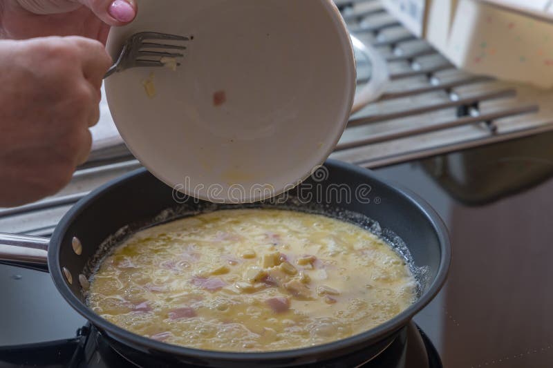 Female Hands Pouring a Mixture of Raw Eggs with Cheese into a Frying ...